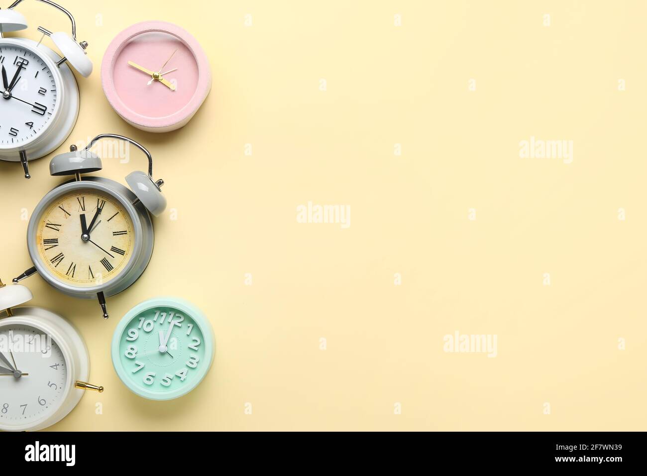 Different alarm clocks on color background Stock Photo - Alamy