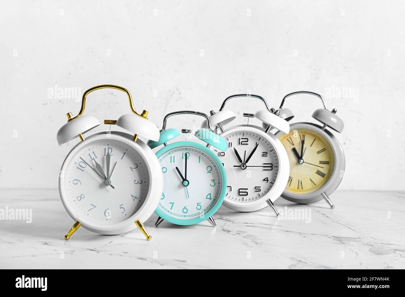 Different alarm clocks on light background Stock Photo - Alamy
