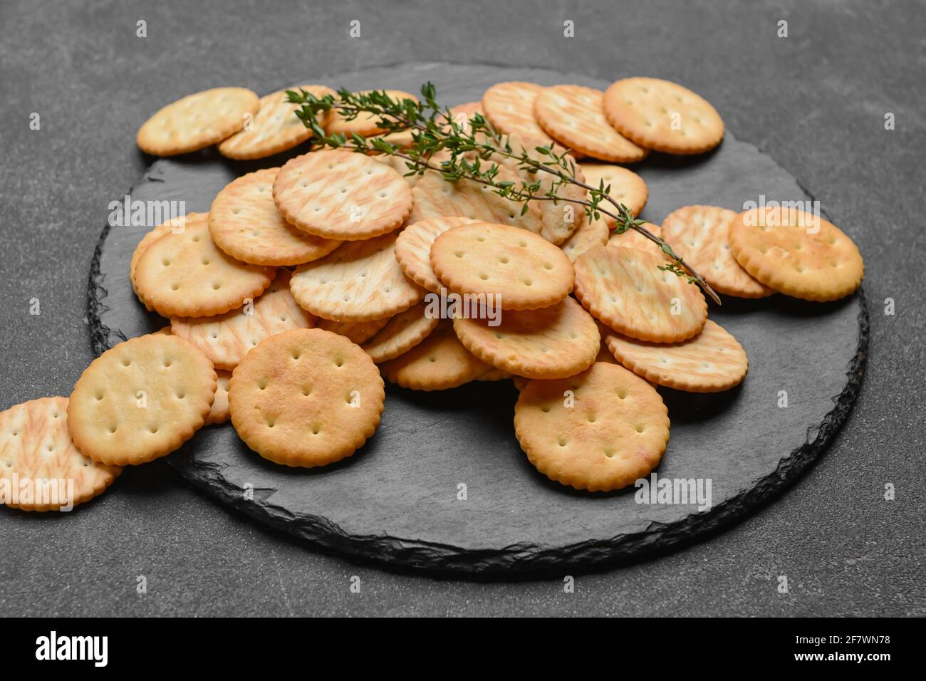 Plate with crackers on dark background Stock Photo - Alamy