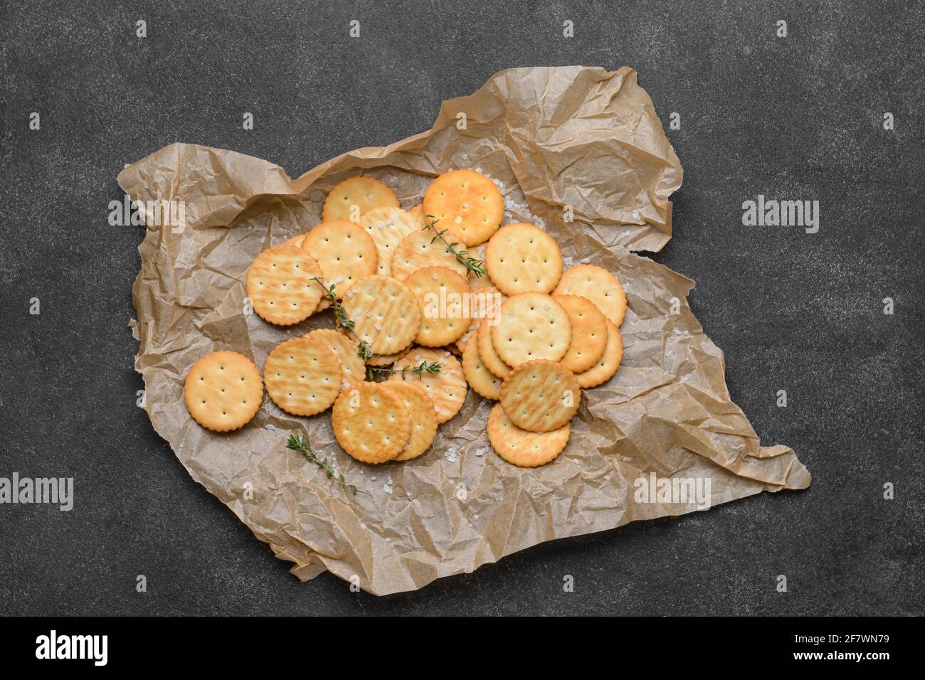 Parchment paper with crackers on dark background Stock Photo - Alamy