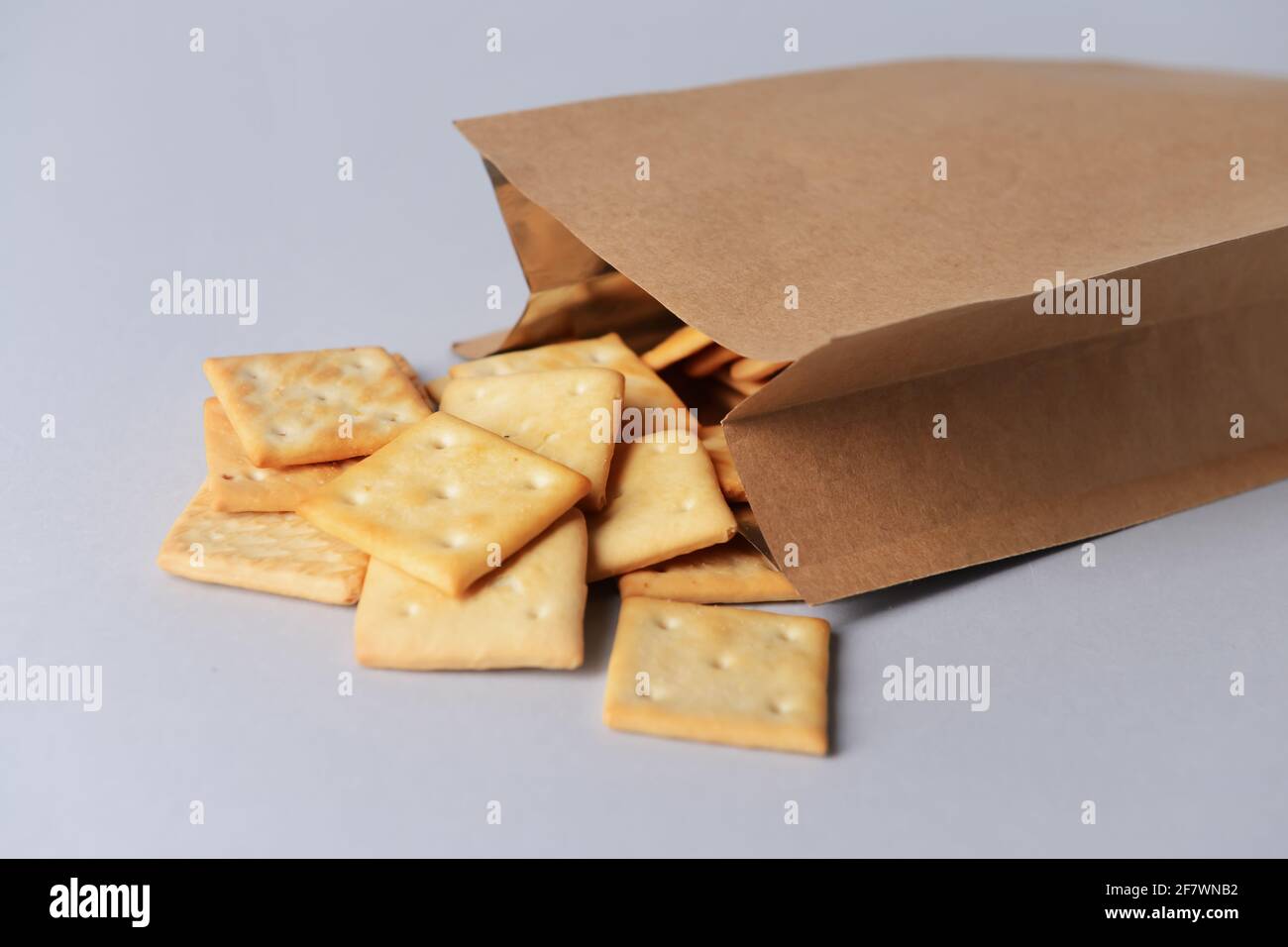 Paper bag of crackers on grey background Stock Photo - Alamy