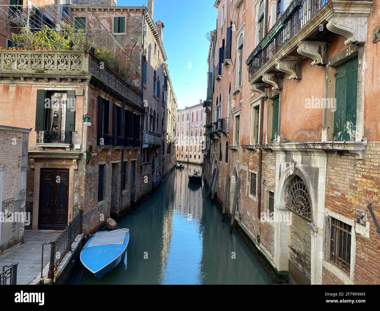 Small boat on a small canal street in Venice with beautiful colorful ...