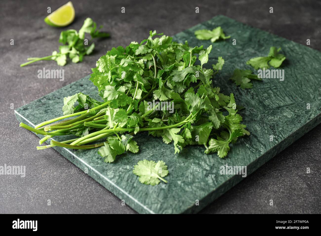 Board with fresh cilantro on dark background Stock Photo - Alamy