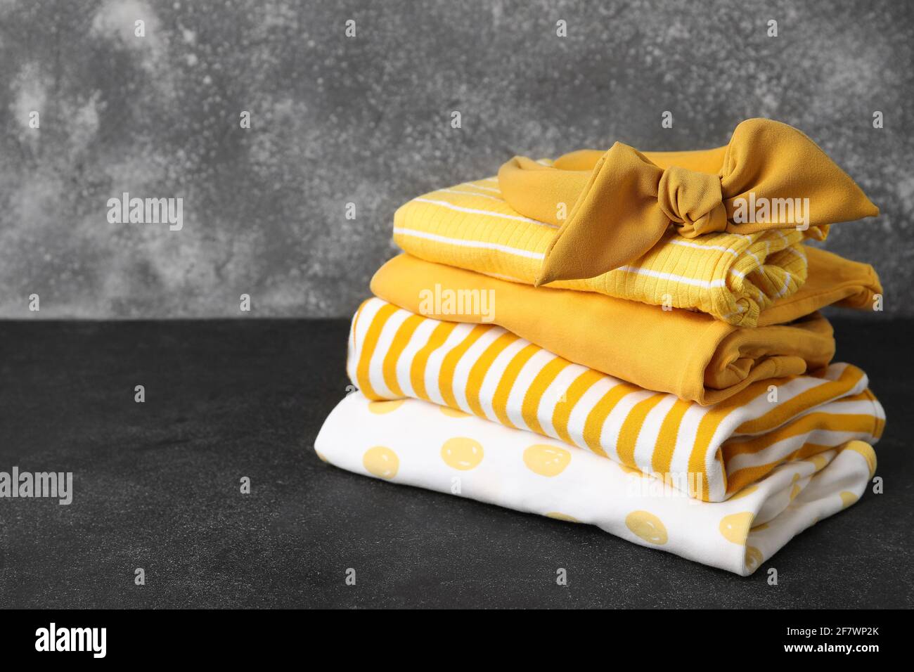 Stack of stylish clothes with headband on grunge background Stock Photo ...