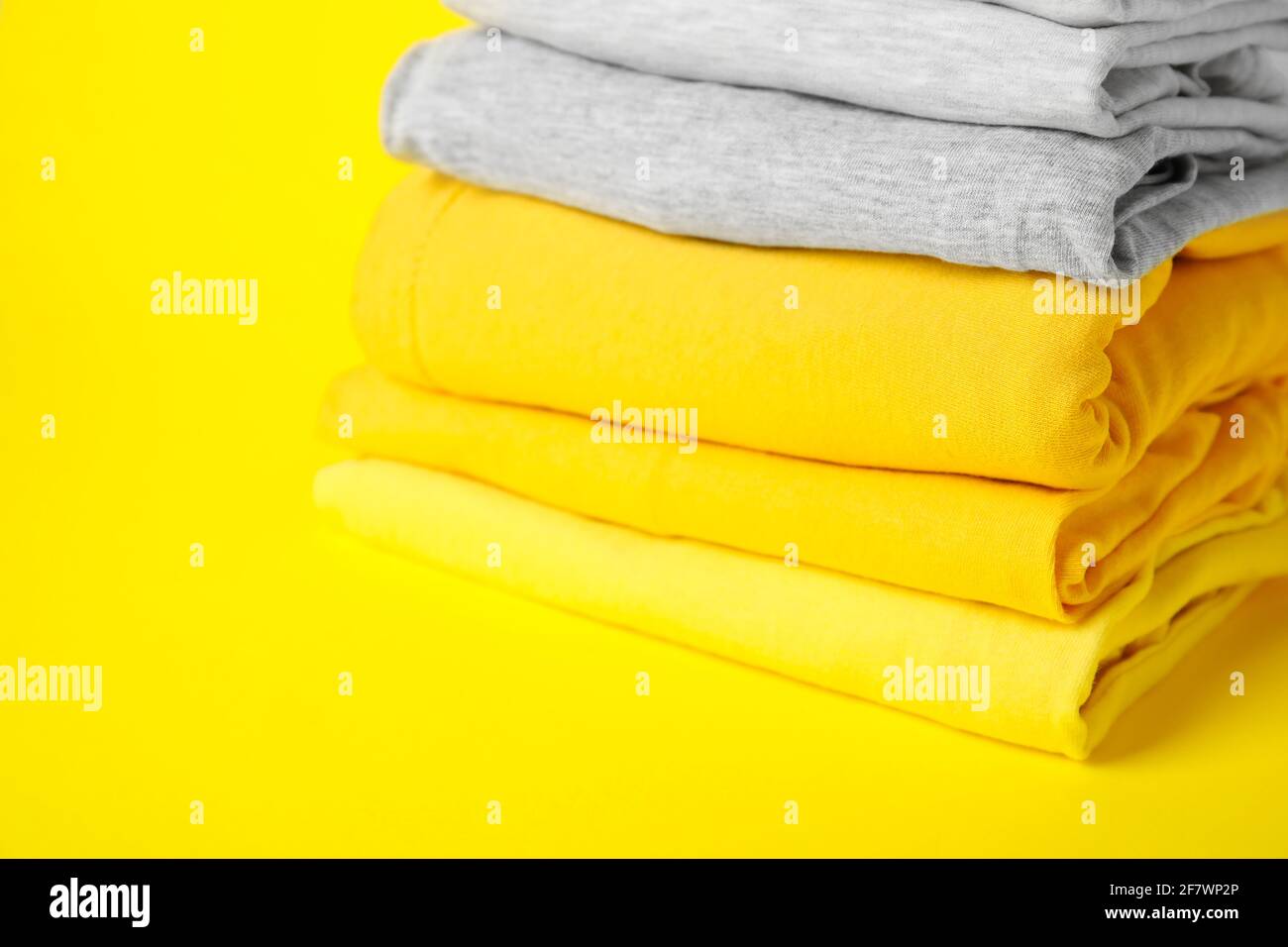 Stack of stylish clothes on color background Stock Photo - Alamy