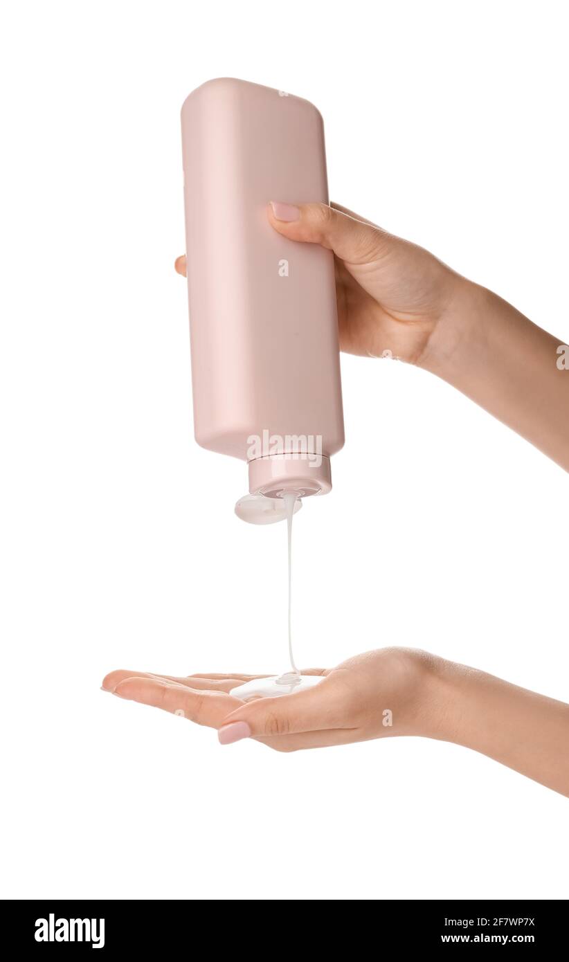 Woman pouring shower gel from bottle onto hand on white background ...