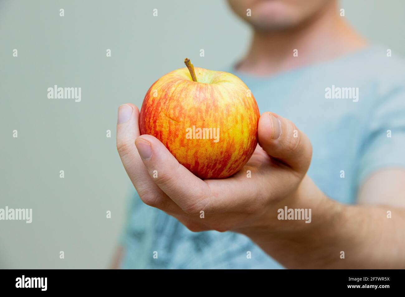 Male hand holding an apple Stock Photo - Alamy