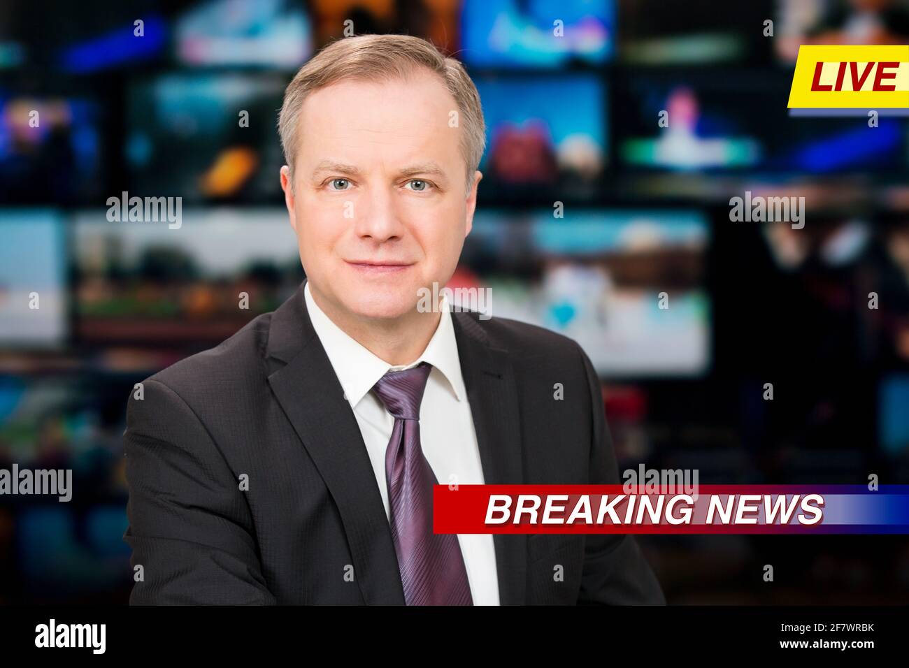 An anchorman reporting live breaking news sitting in Tv studio ...