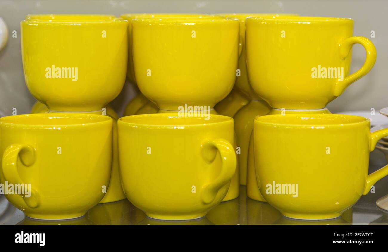Closeup shot of yellow mugs on a shelf Stock Photo - Alamy