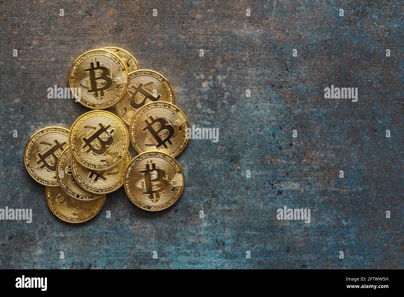 Overhead view of a heap of bitcoins on a textured background and copy ...