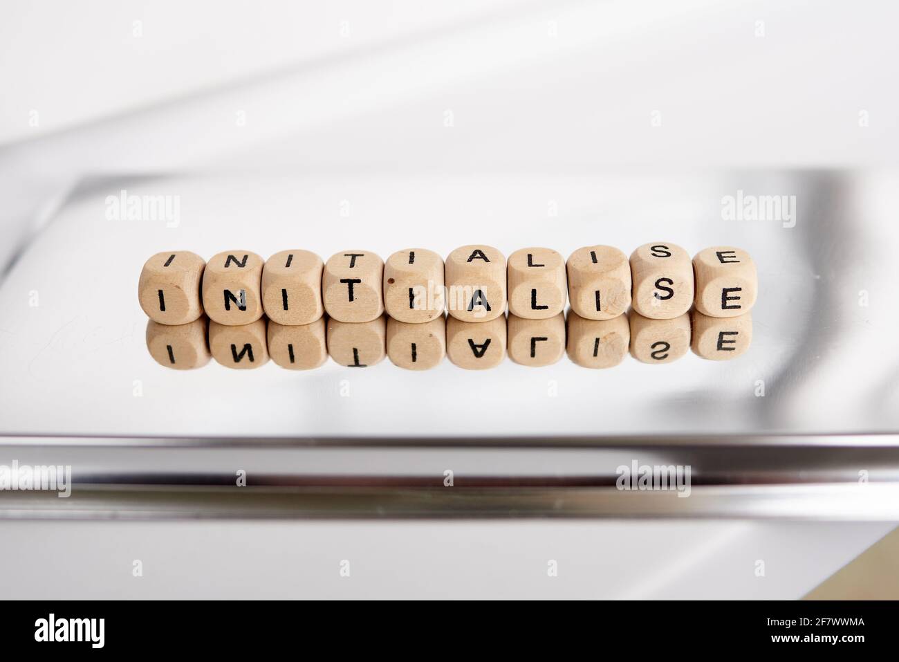 Word initialise made by wooden cubes Stock Photo - Alamy