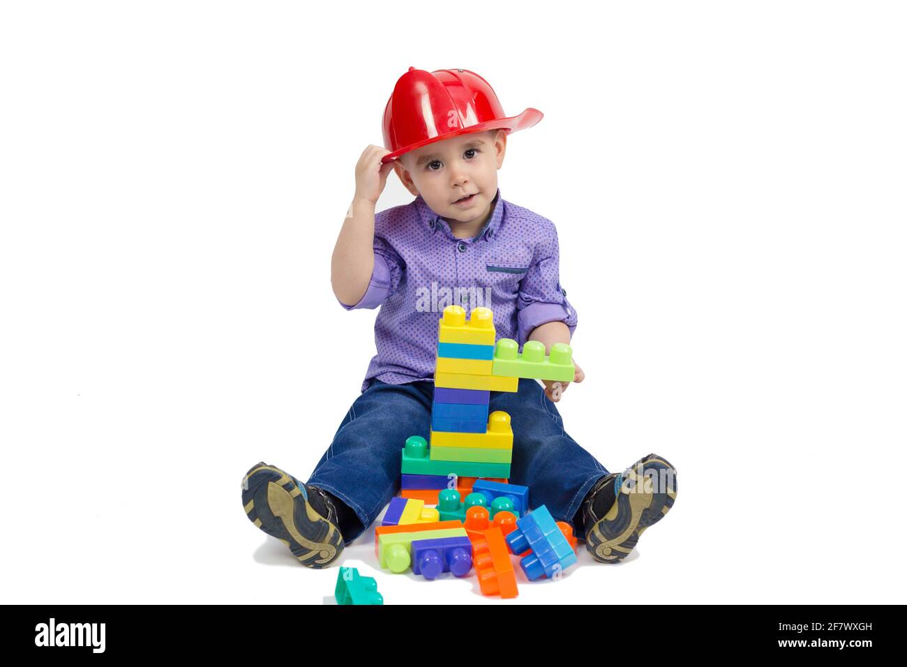 The child sits on the floor with toys spread out between his legs ...