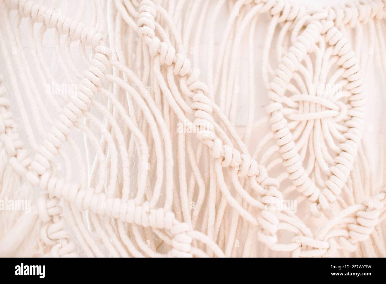 fragment of wall panel in boho style made of cotton threads of natural ...