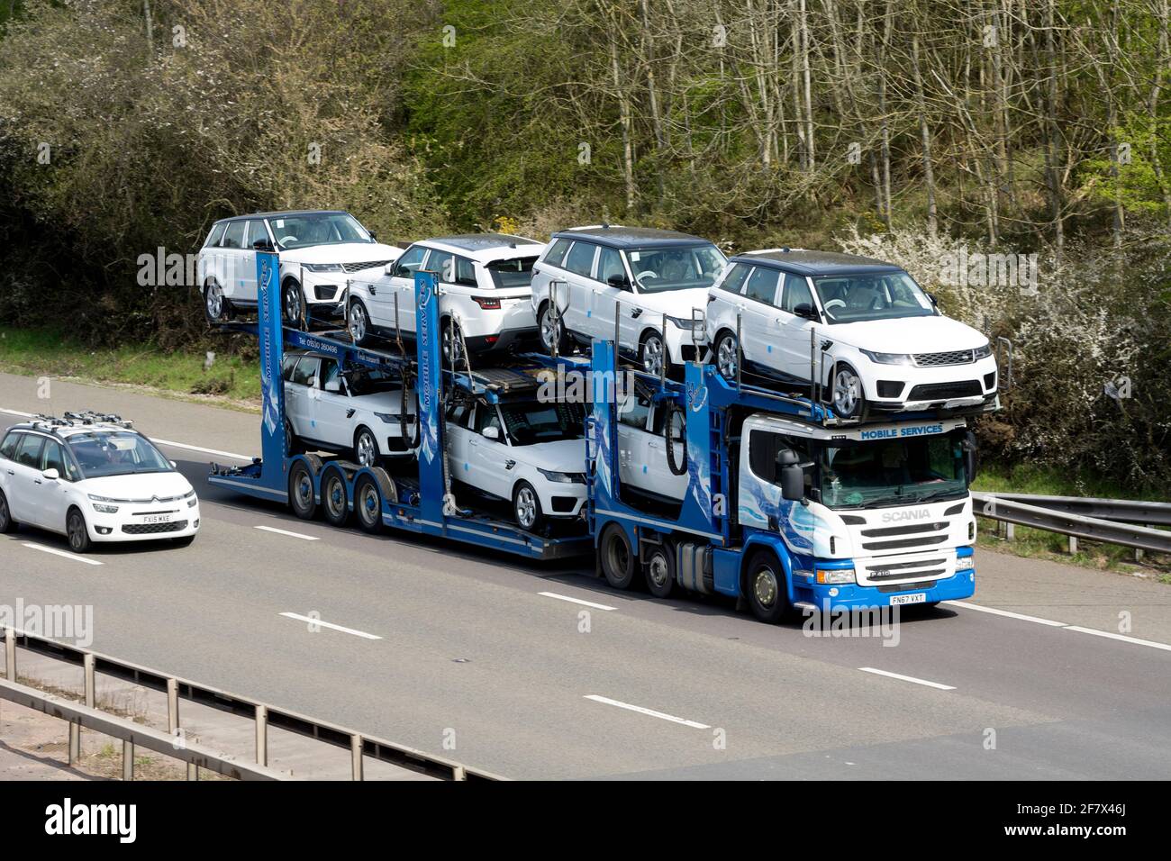 A Scania Mobile Services transporter lorry carrying new white Land ...