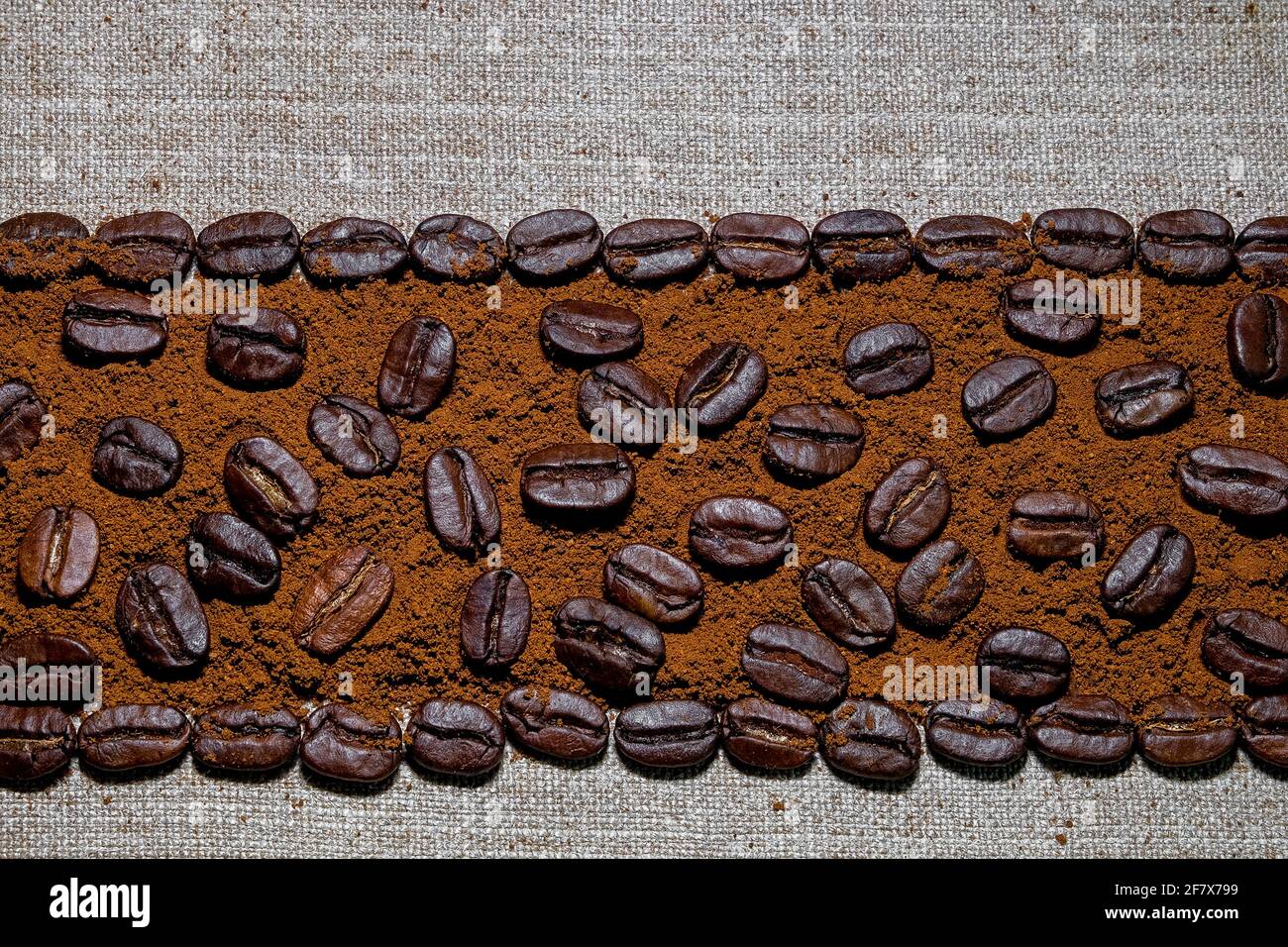 frame lined with black coffee beans and ground coffee on the background ...