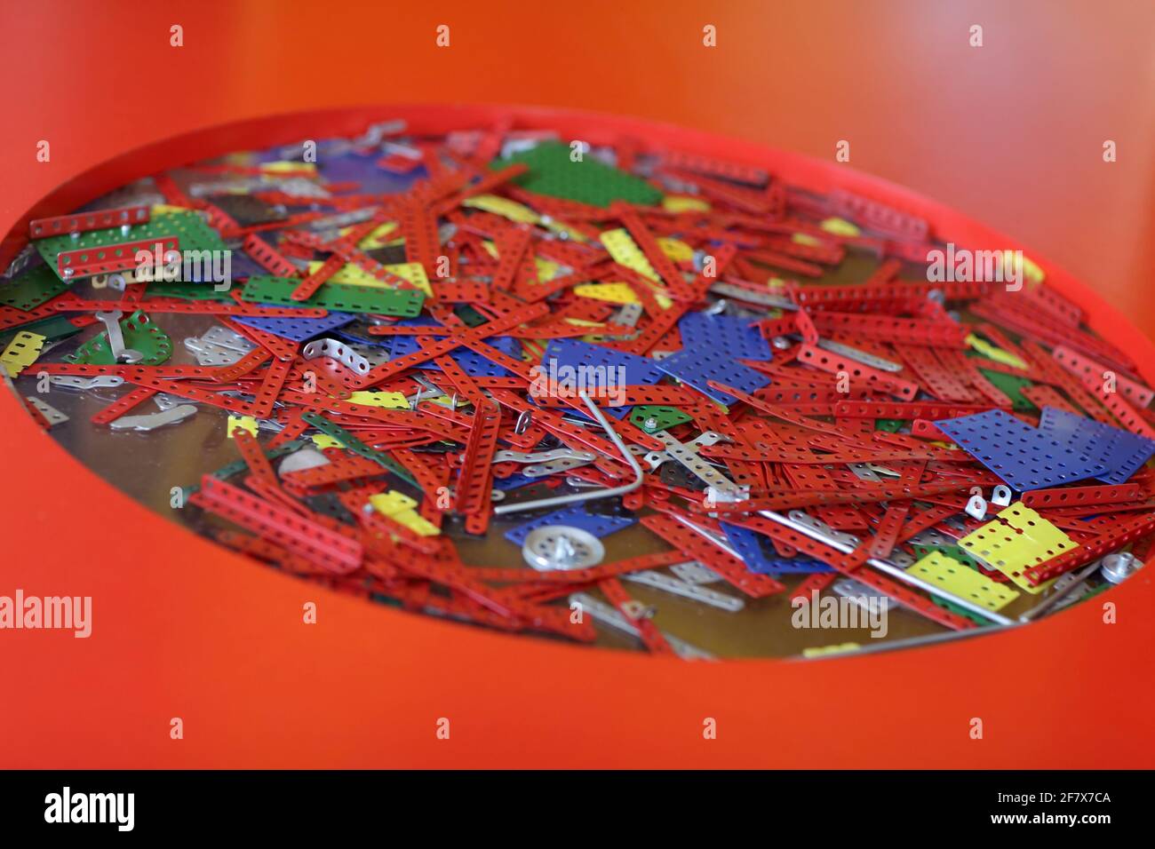 Pieces of vintage construction set on a red table Stock Photo - Alamy