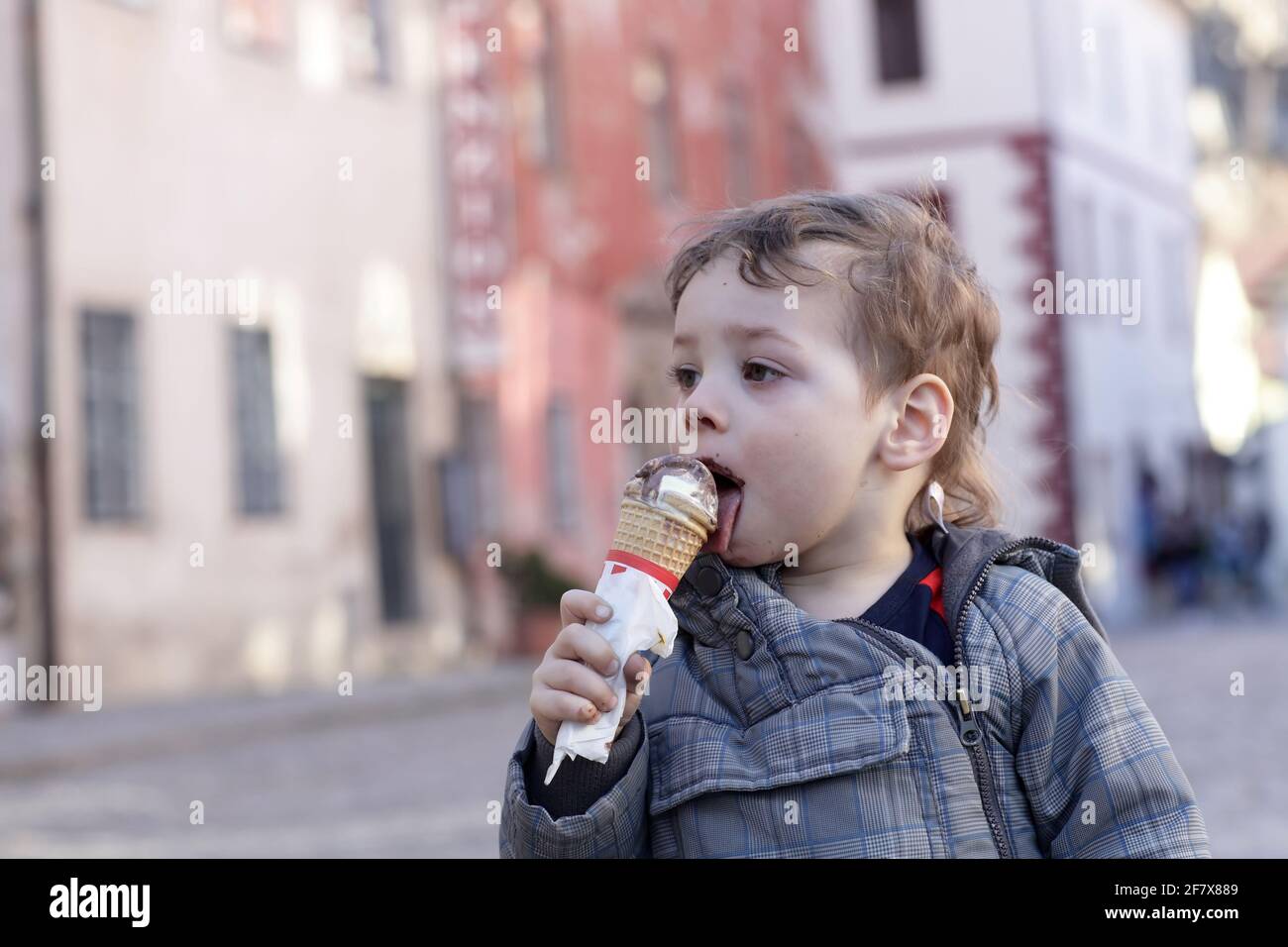 Kid licks ice cream on the street Stock Photo - Alamy