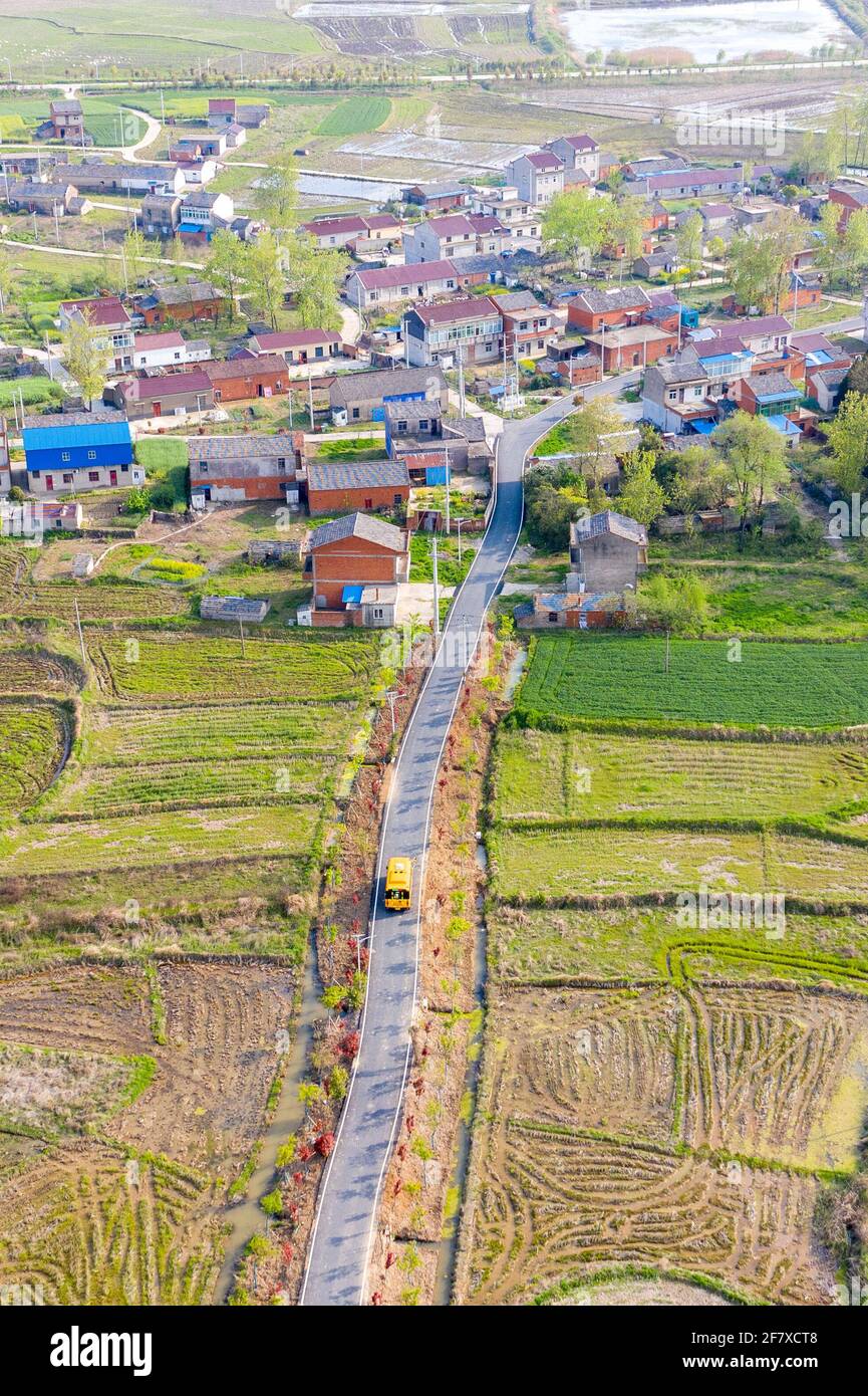 HEFEI, CHINA - APRIL 9, 2021 - A school bus takes students home on a rural road as parents pick ...