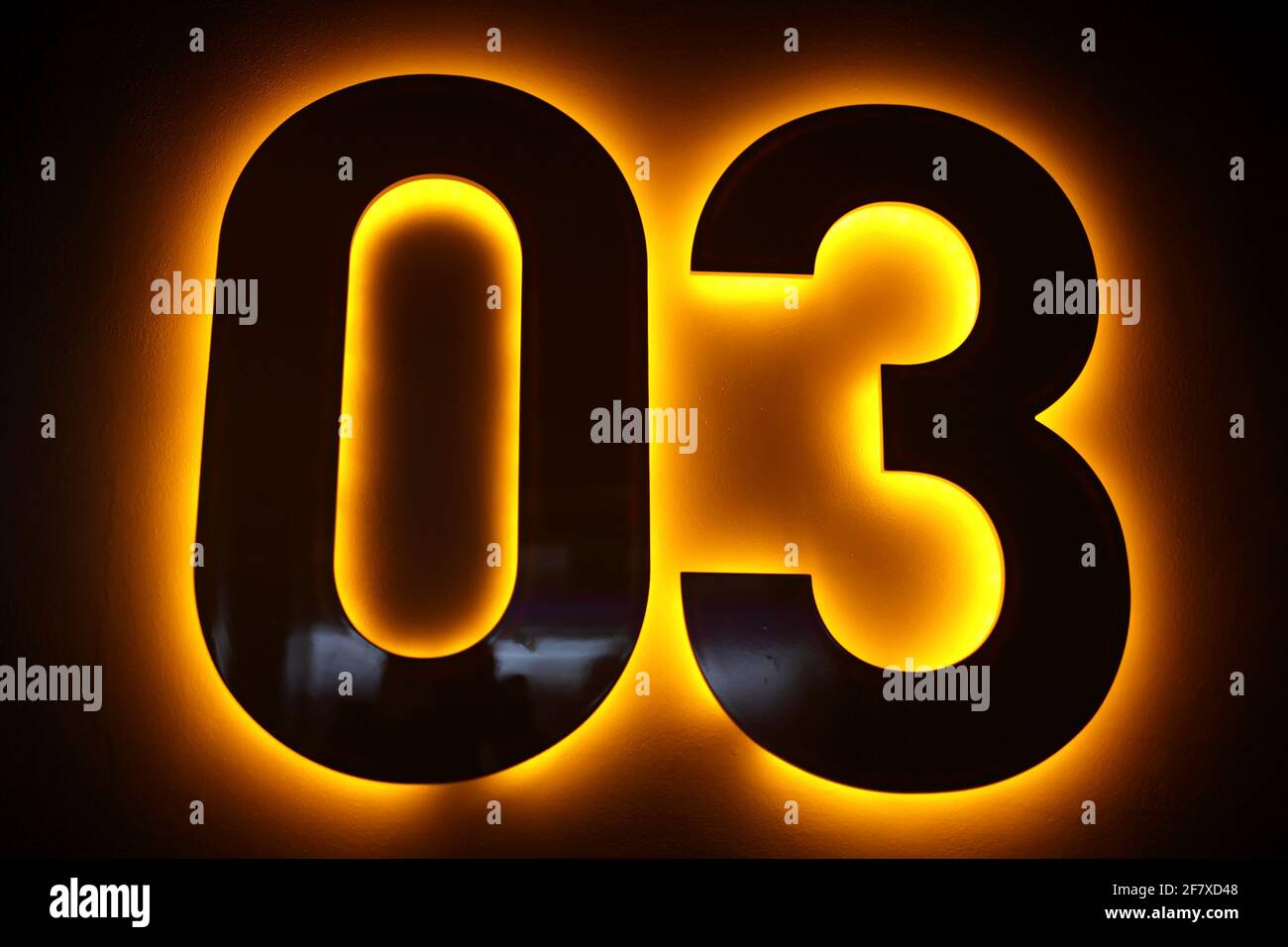 Luminescent numerals zero and three on a wall Stock Photo - Alamy
