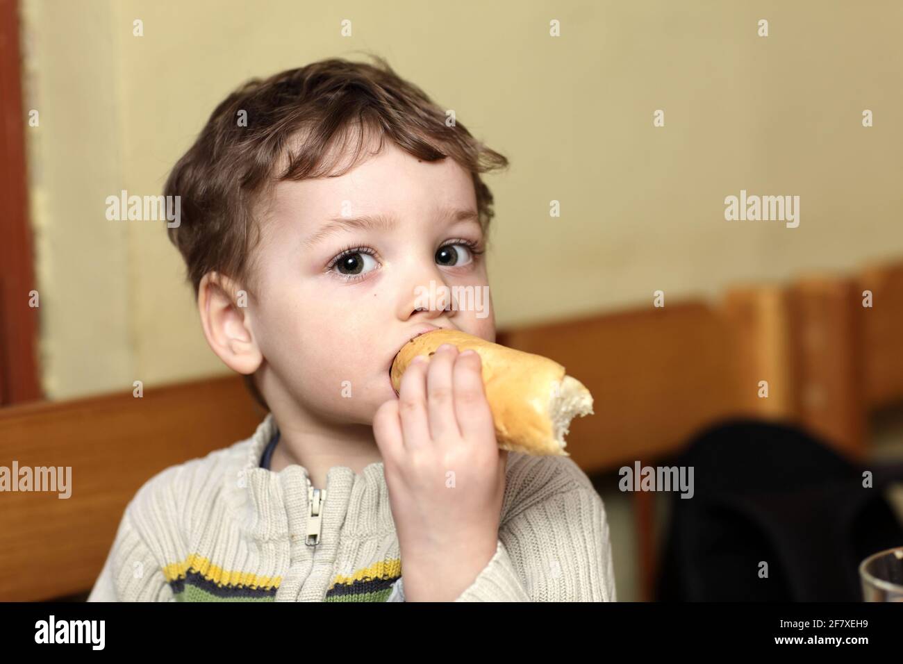 The child eating bun in the cafe Stock Photo - Alamy