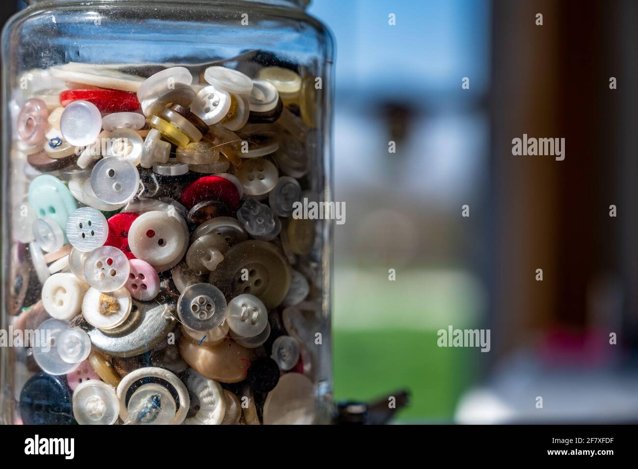 various types of buttons stored in a glass container Stock Photo - Alamy
