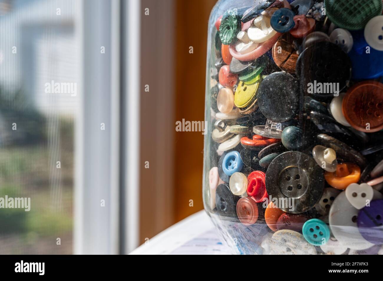 various types of buttons stored in a glass container Stock Photo - Alamy