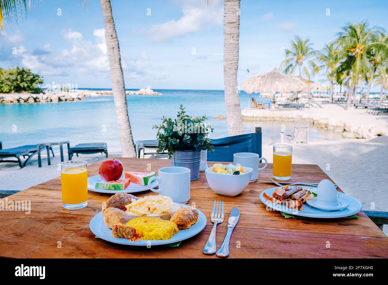 breakfast on a table by the beach looking out over the ocean, Caribbean ...