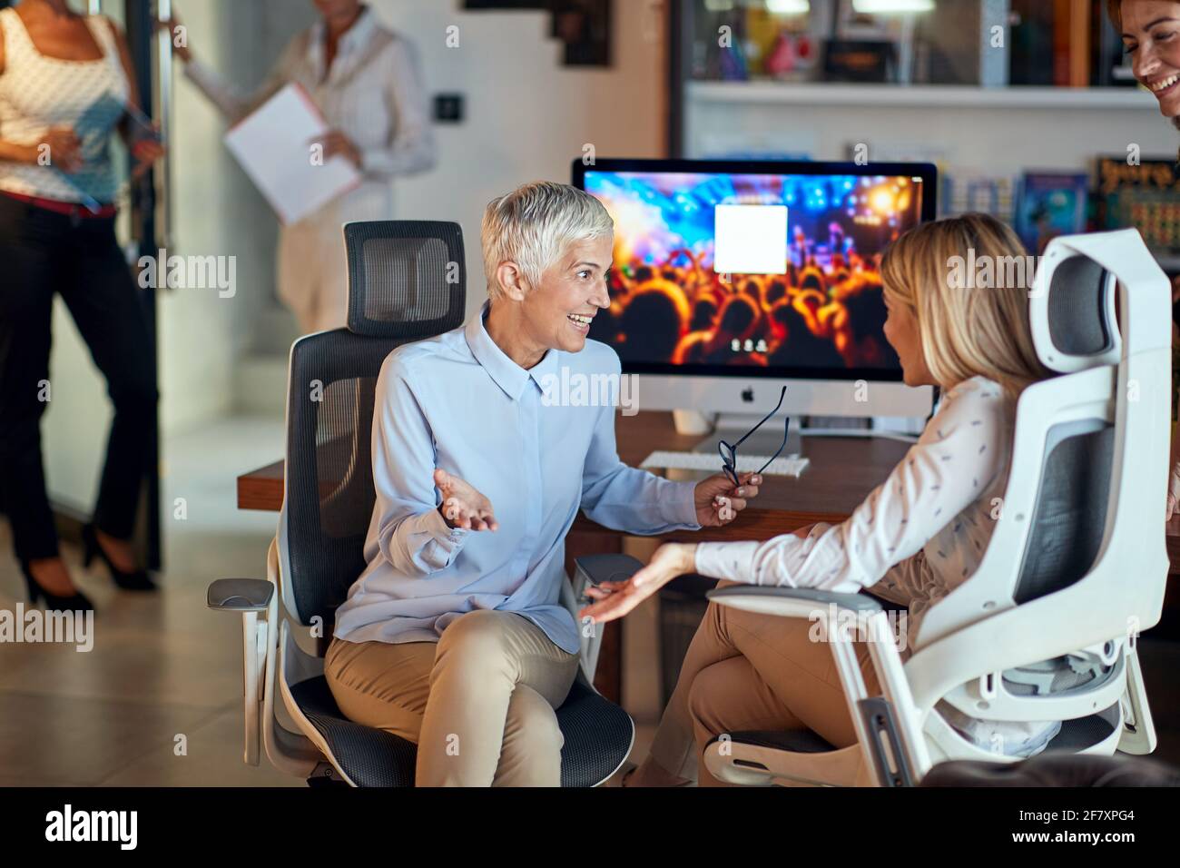 Female colleagues have a friendly talk while sitting comfortably in ...