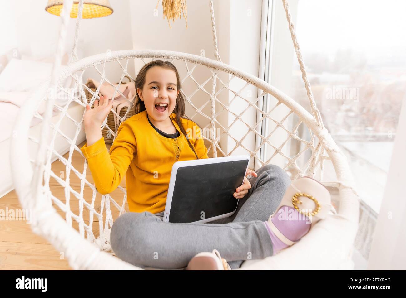 Cute girl lying on sofa with tablet computer Stock Photo - Alamy