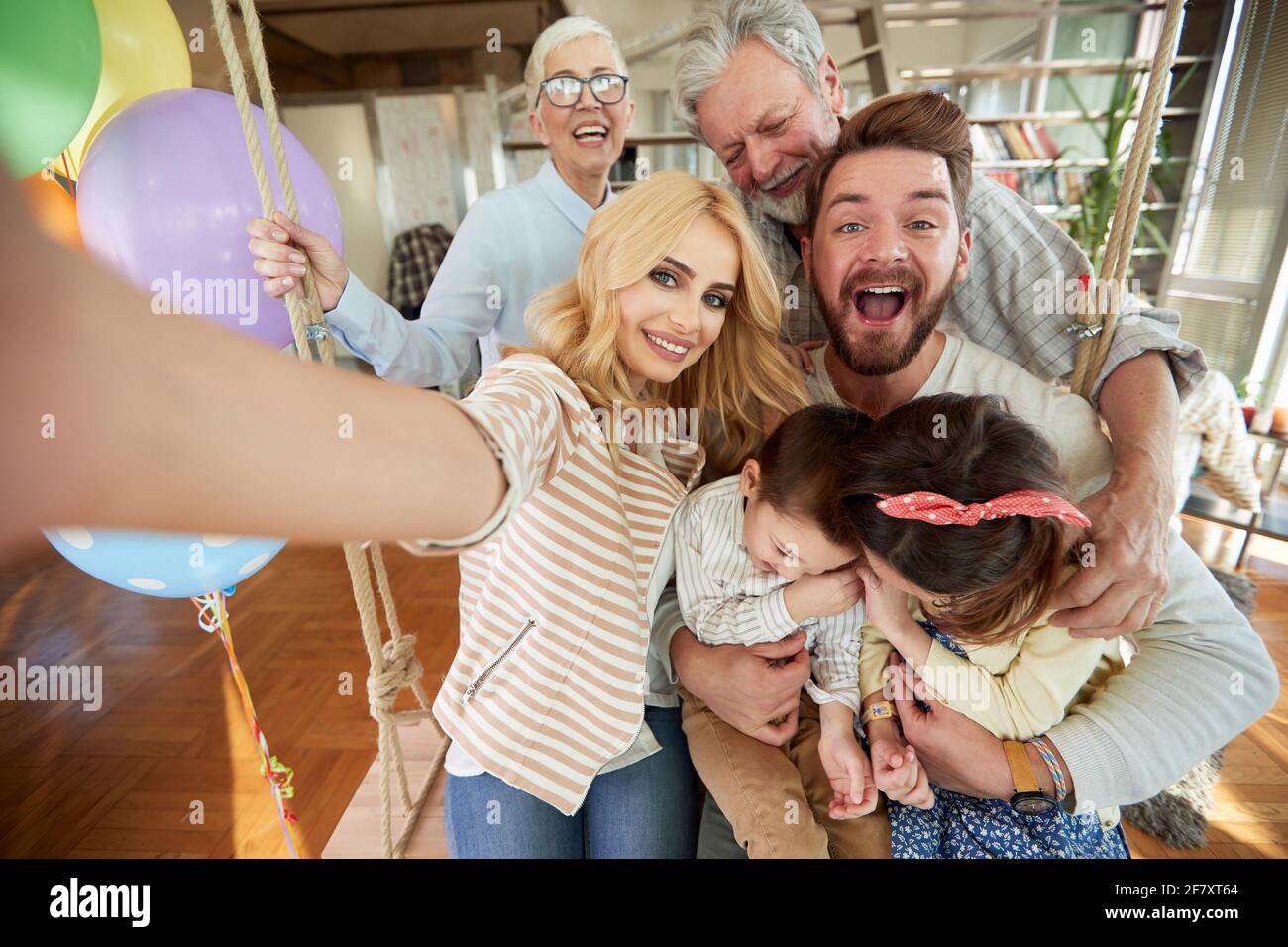 Happy family portrait with grandparents at home; Happy family offspring ...