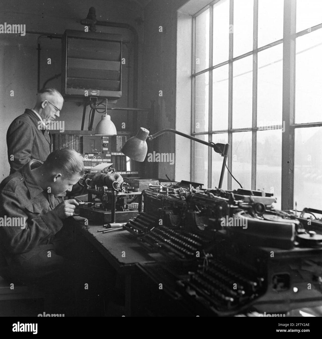 Typewriter / telex equipment Repair workshop with mechanics at work ...