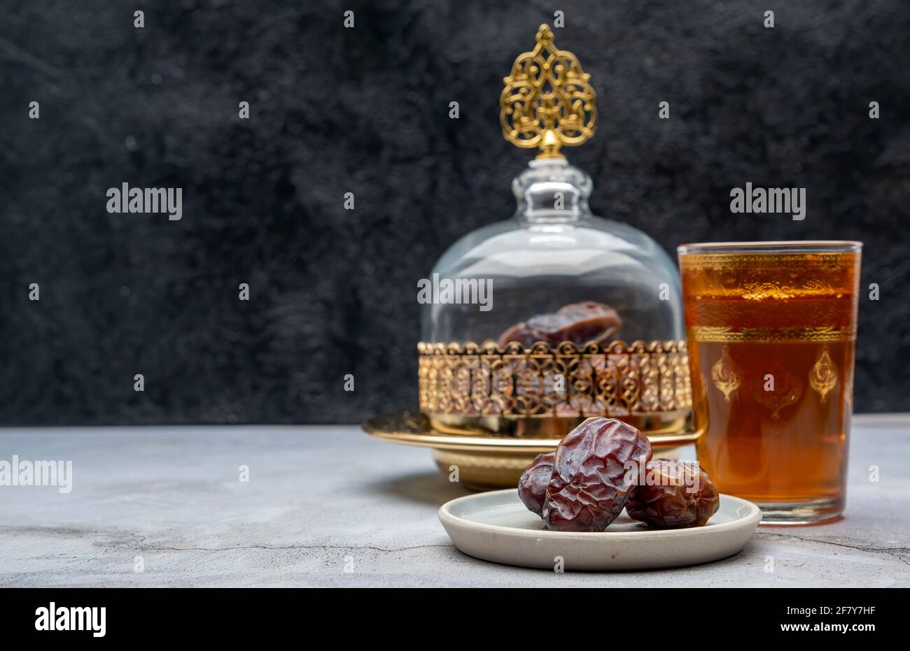 Date in Glass dome and gold plate on table side view with writing space ...