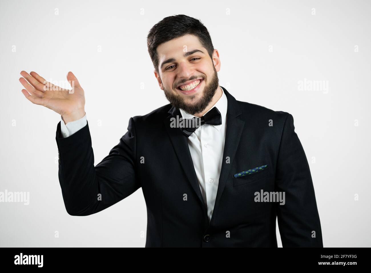 Young friendly man in tuxedo waving hand - hello. Greeting, say Hi to ...