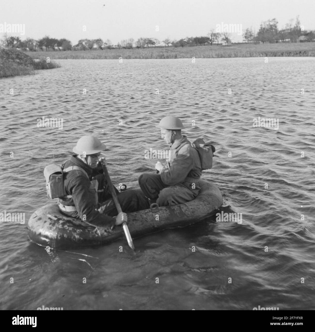 Soldiers use a small inflatable rubber boat to cross a channel Stock ...