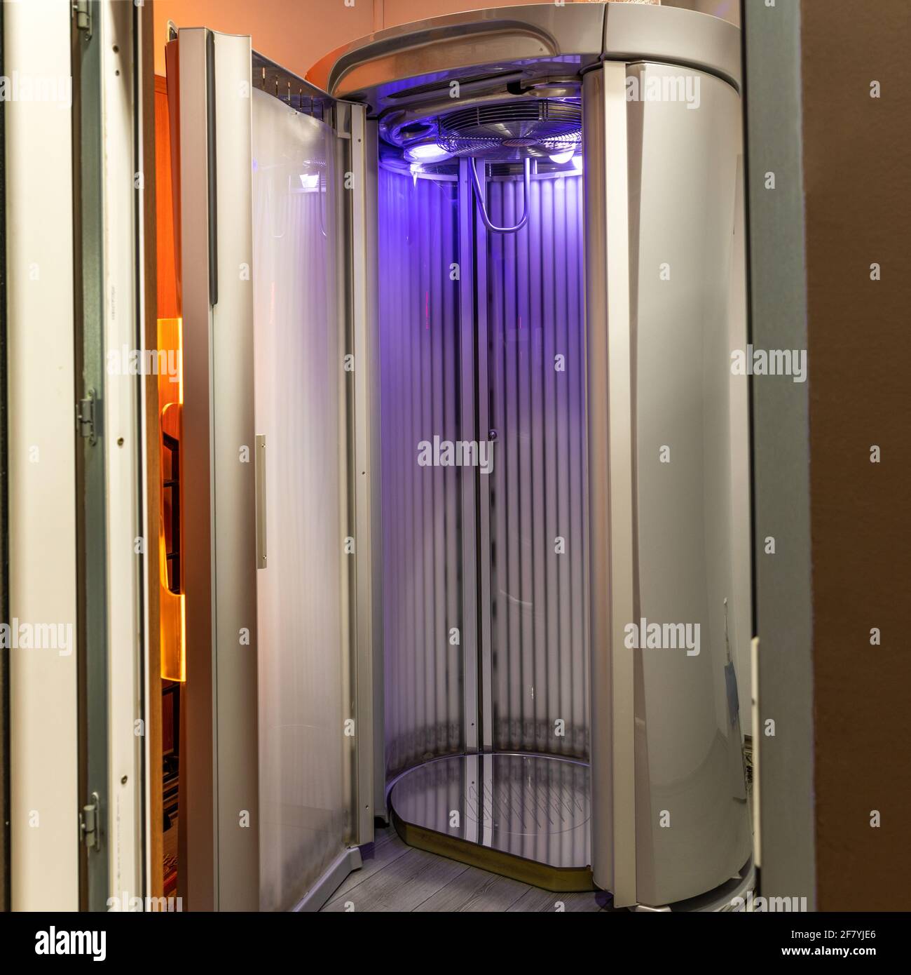 Standing empty solarium with purple light Stock Photo - Alamy