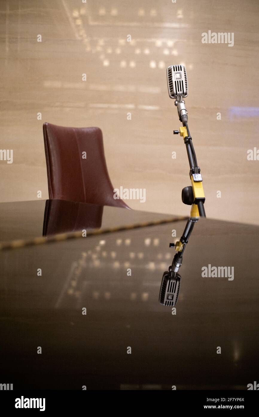 Professional microphone in a studio with a reflective table and leather ...
