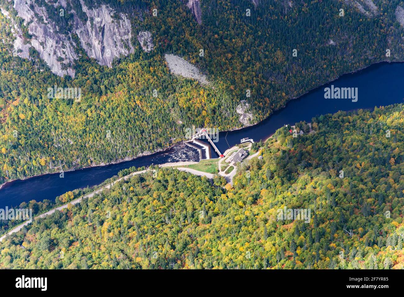 view of a river with a barrage in the middle of the forest in summer ...