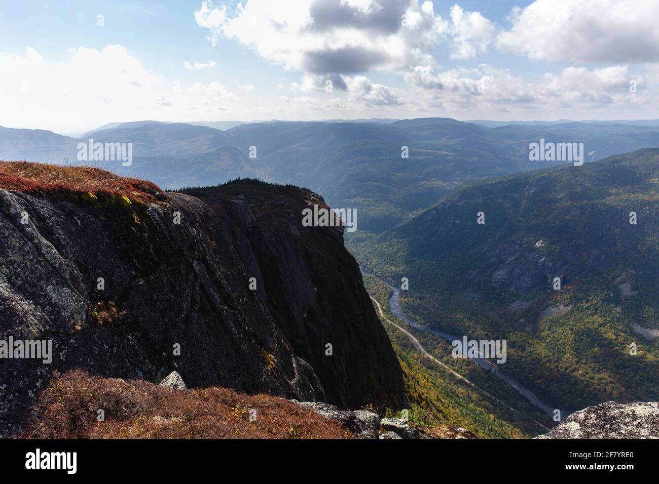 tall cliff and view of a valley in summer with clouds in the sky Stock ...