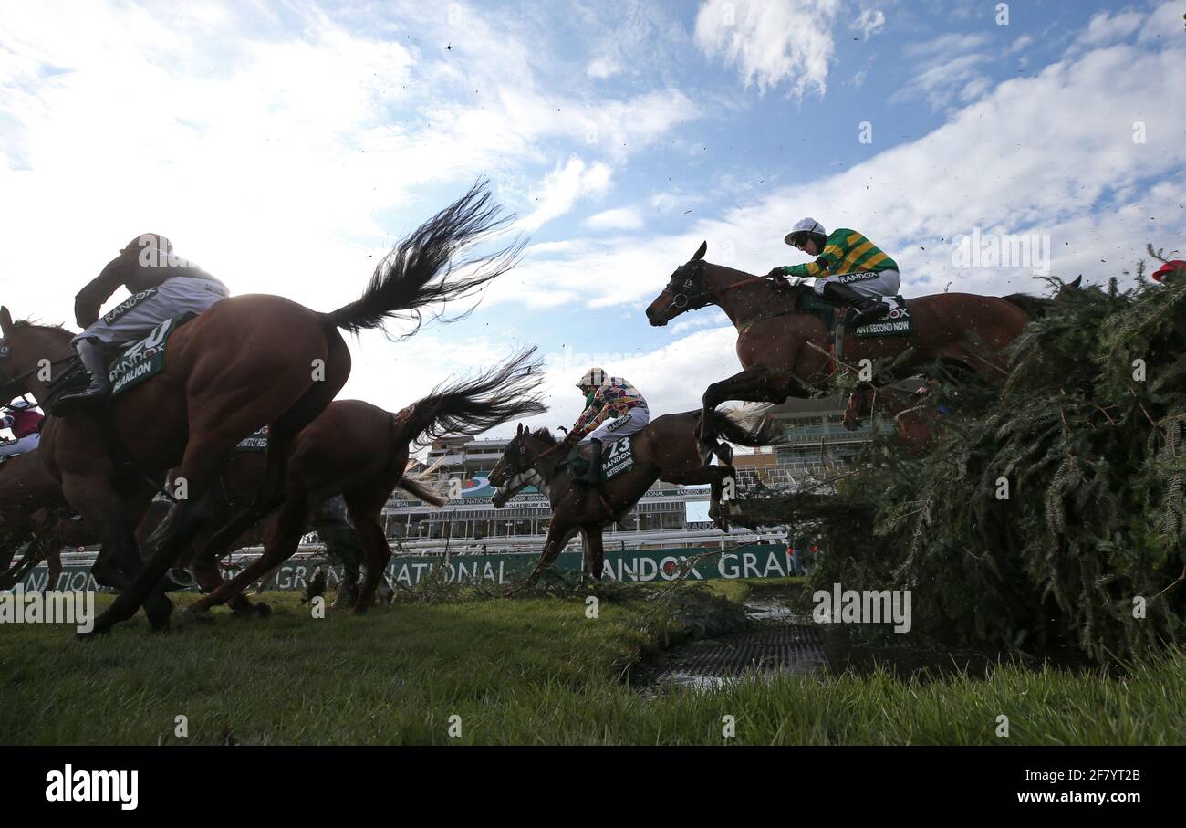 Runners and riders clear the water jump during Grand National Day of ...