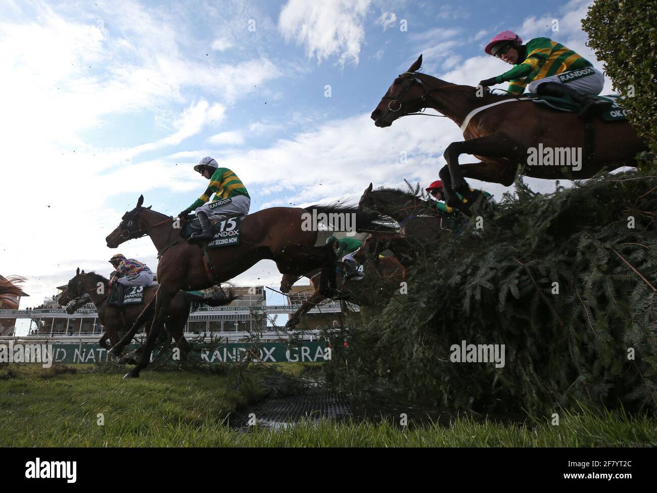 Runners and riders clear the water jump during Grand National Day of ...