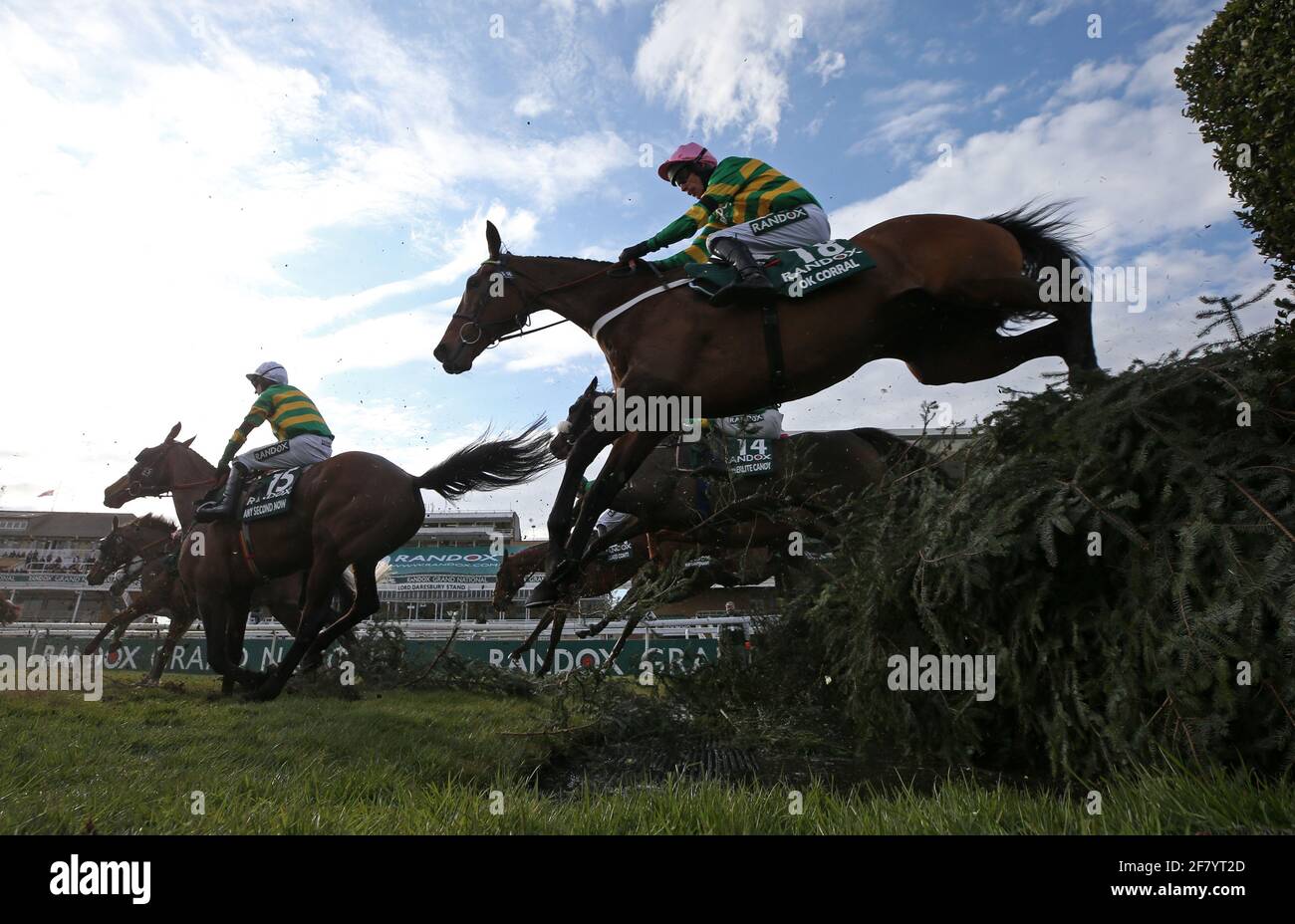 Runners and riders clear the water jump during Grand National Day of ...