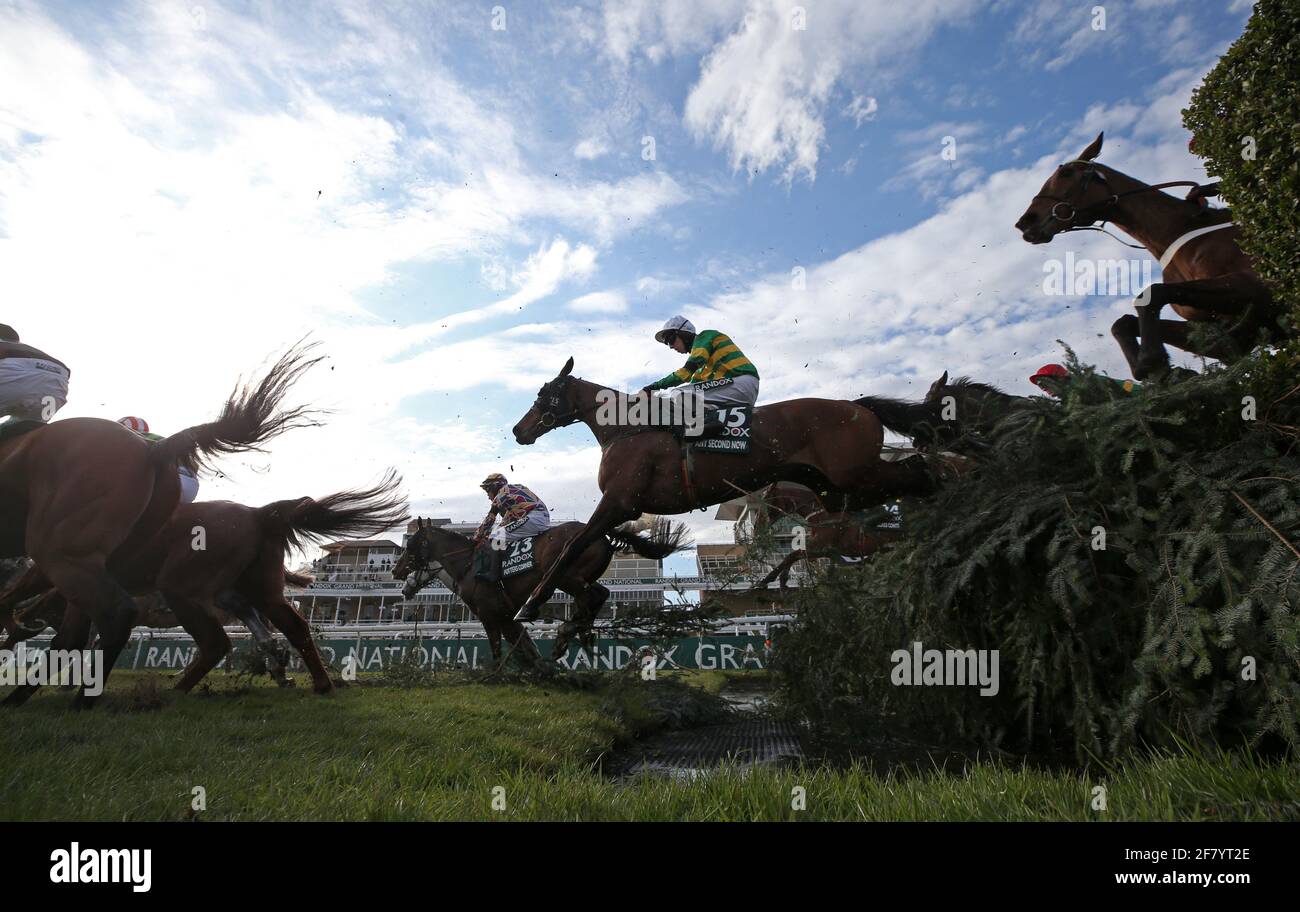 Runners and riders clear the water jump during Grand National Day of ...