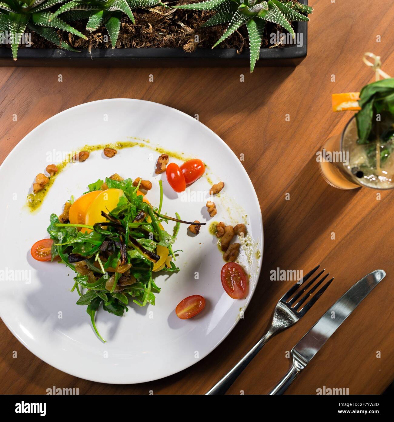Top view of a bar table with a plate of vegetarian food and a glass of ...