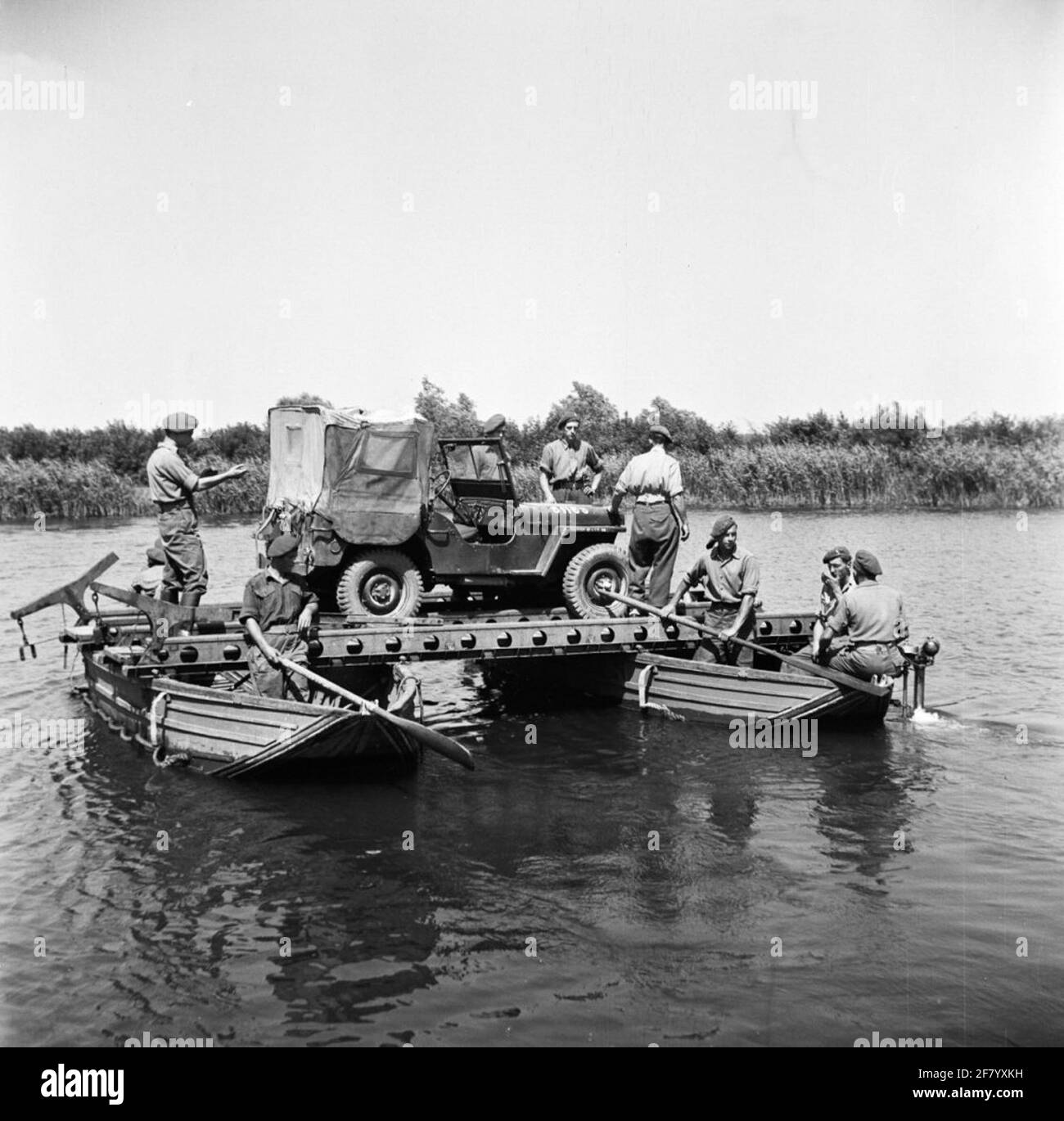 Pontonniers transport a Willy Jeep on a folding boat raft when crossing ...