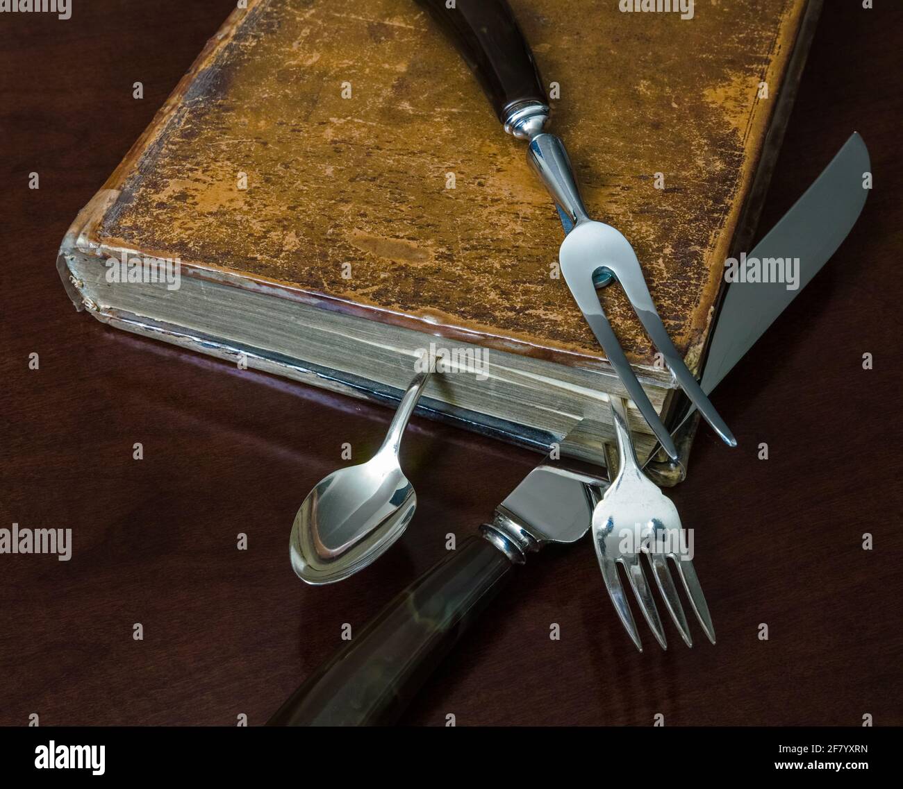 A very old cookbook and classic utensils. Low key Stock Photo - Alamy