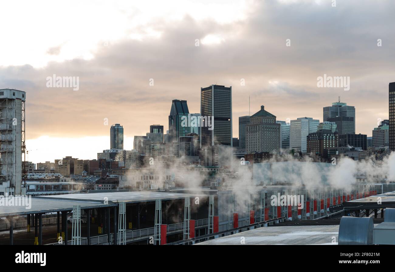 sunset in a city with shadows of tall buildings in summer with smoke in ...