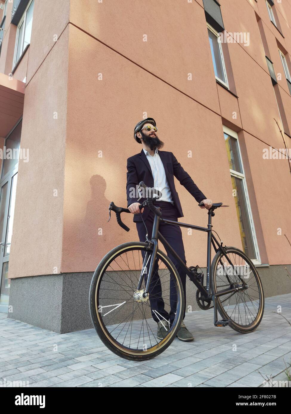 A young stylish businessman pushing a bicycle while going to work Stock ...