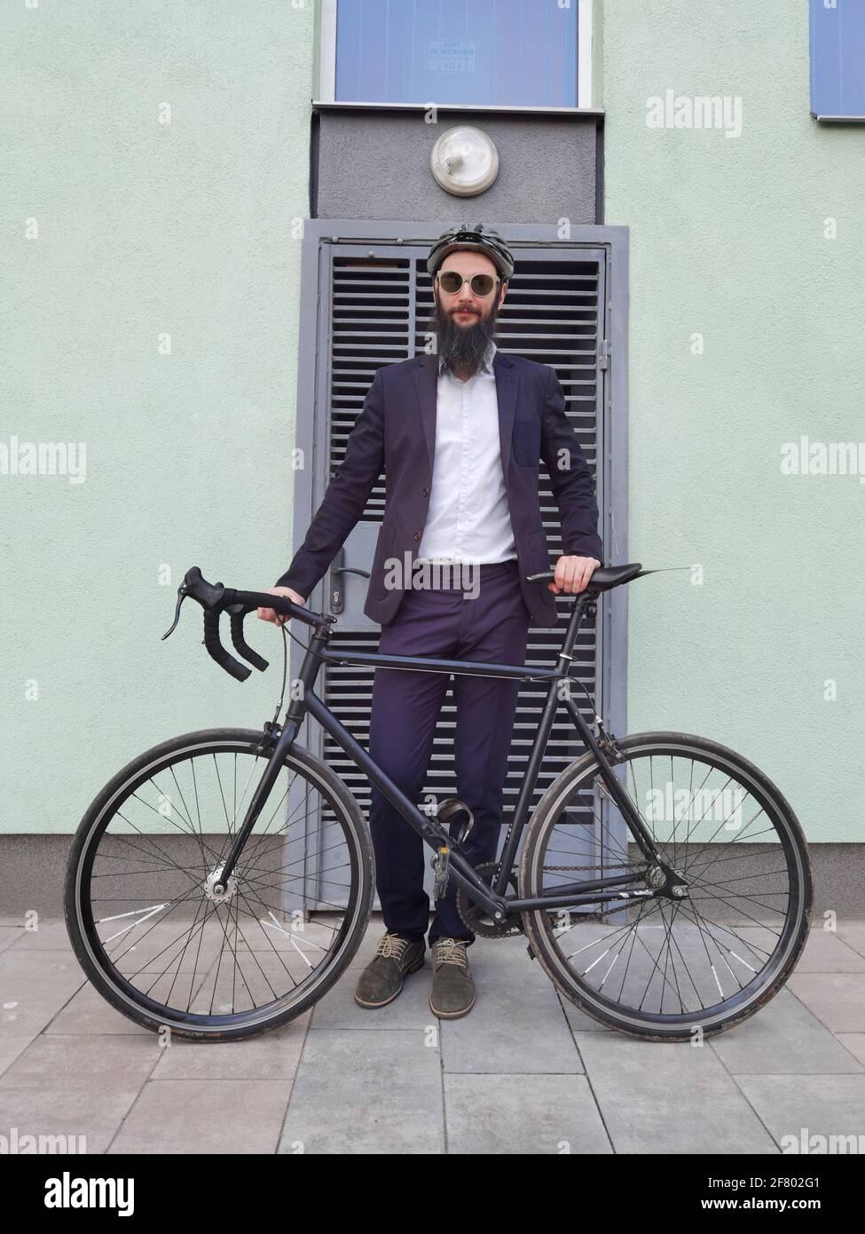 A young stylish businessman pushing a bicycle while going to work Stock ...