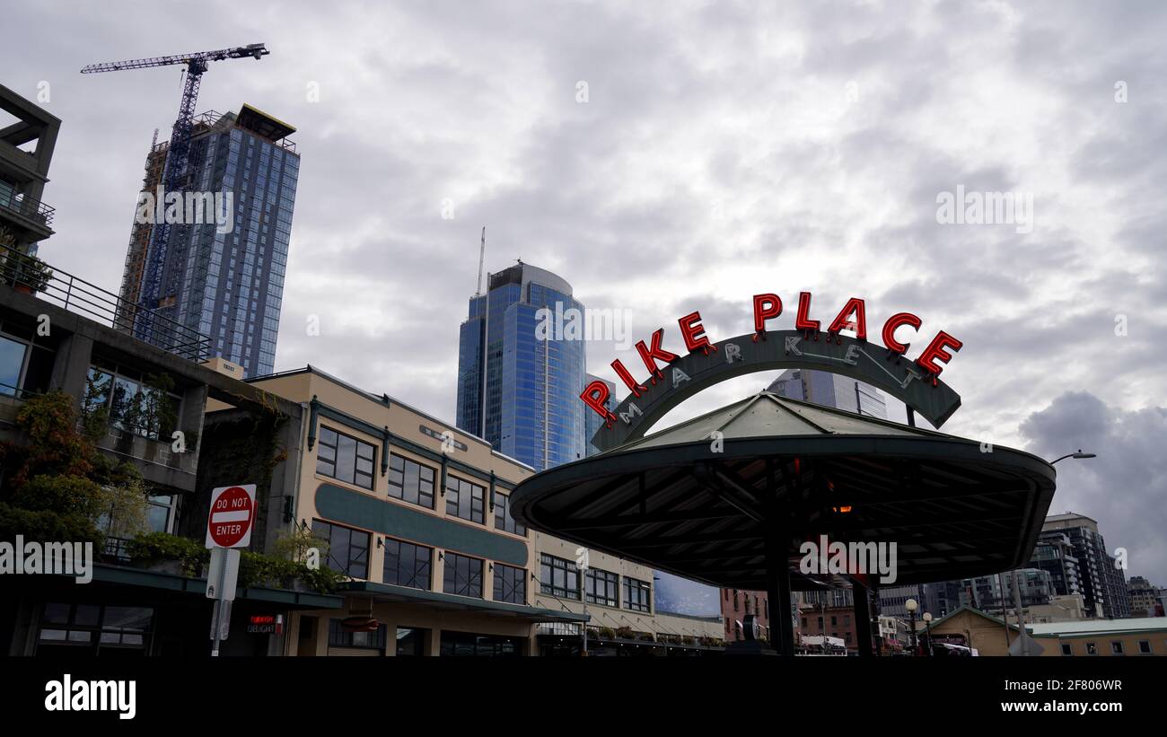 Pike Place Market entrance with tall buildings far away under cloudy ...
