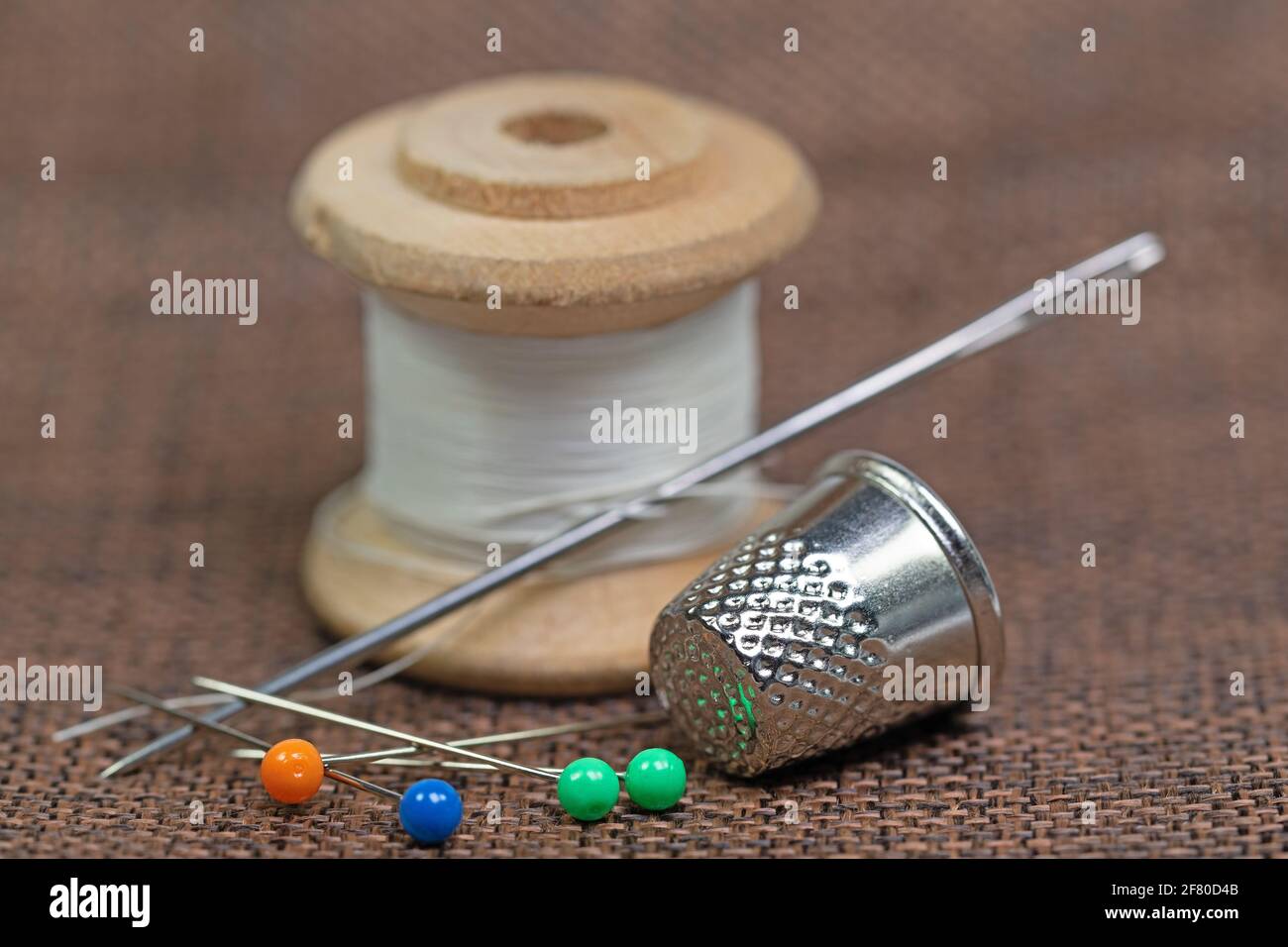 Sewing thread, needles and thimble in close up Stock Photo - Alamy